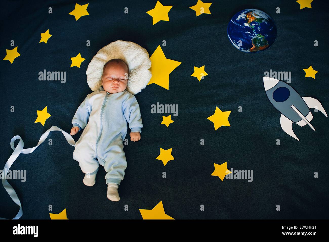 baby boy sleeps on the background of the starry sky with a rocket and ...