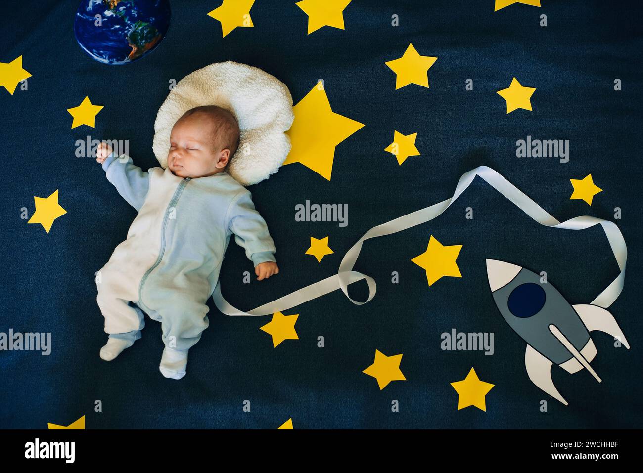 sleeping baby boy astronaut on a background of the sky with the space ...