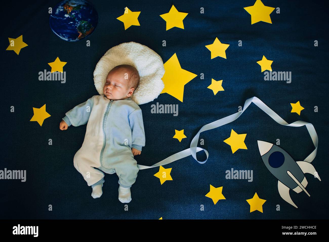 sleeping baby boy astronaut on a background of the sky with the space ...