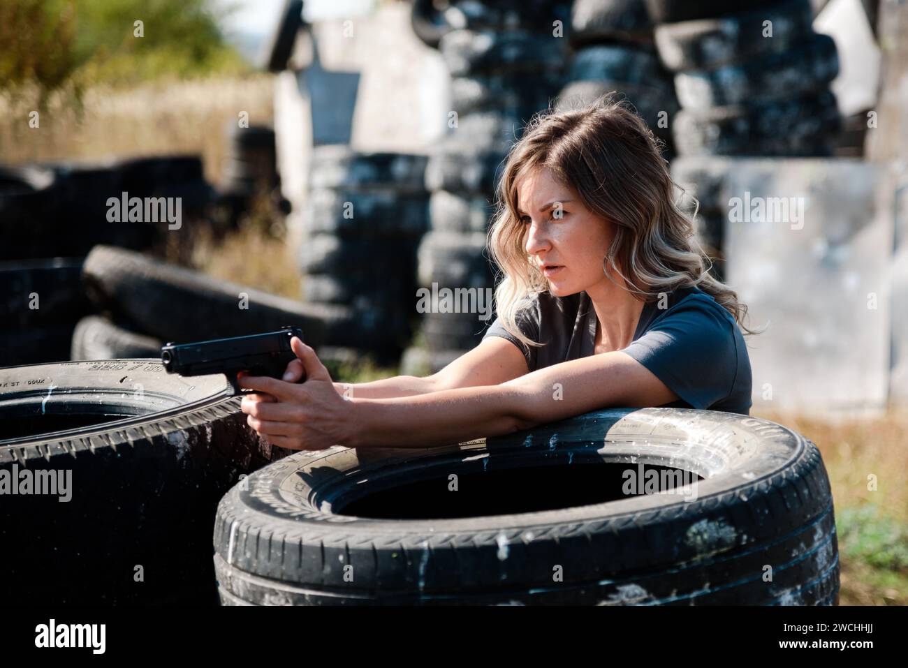 A woman with a pistol in her hand learns to shoot at the shooting range ...
