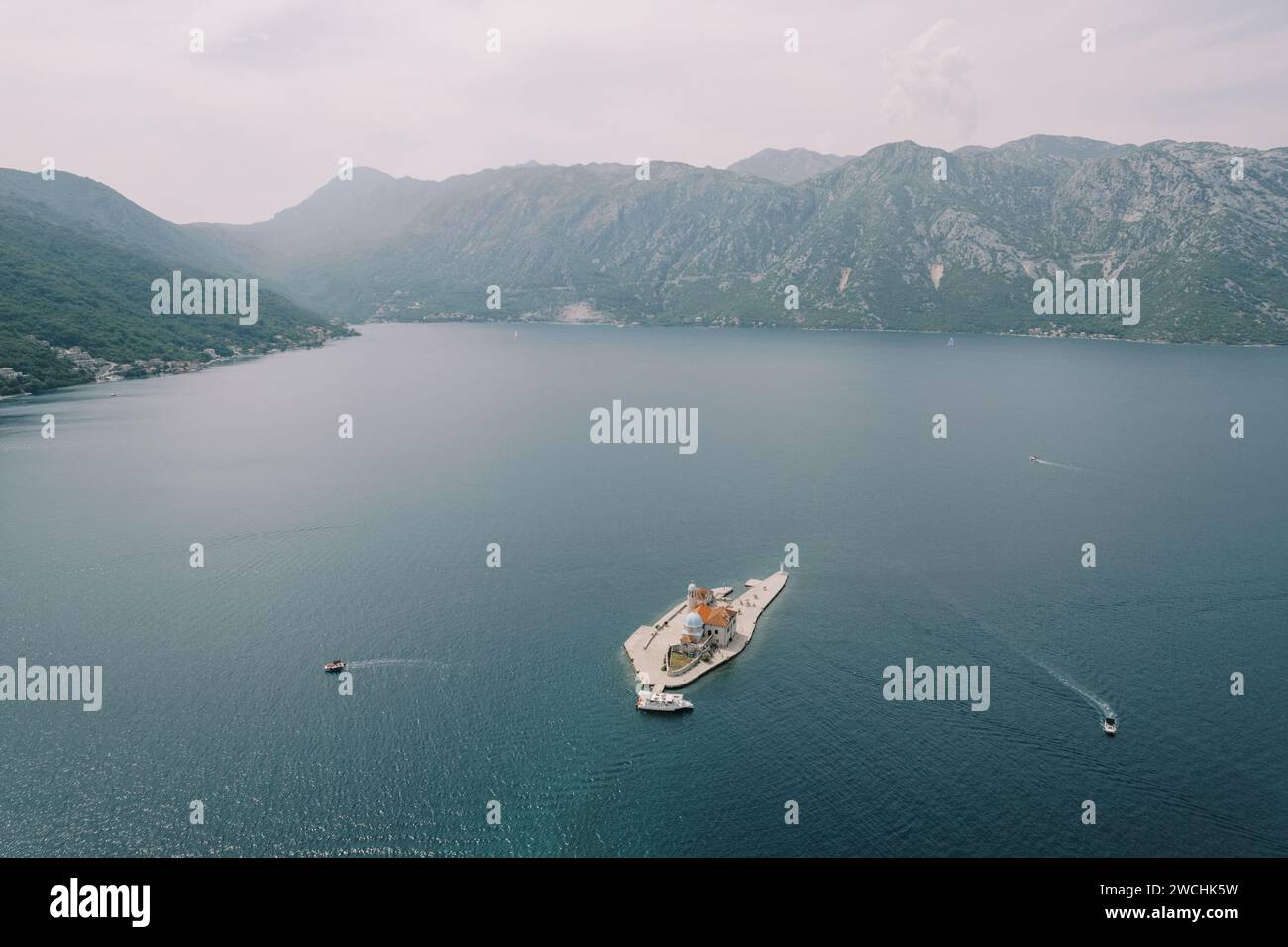 Motor boats sail around the island of Gospa od Skrpjela. Montenegro ...