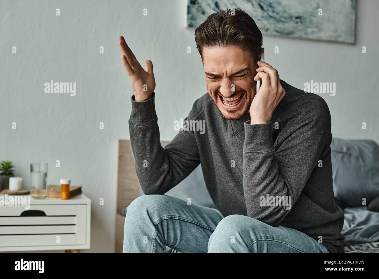 angry bearded man in grey sweater talking on smartphone and gesturing ...