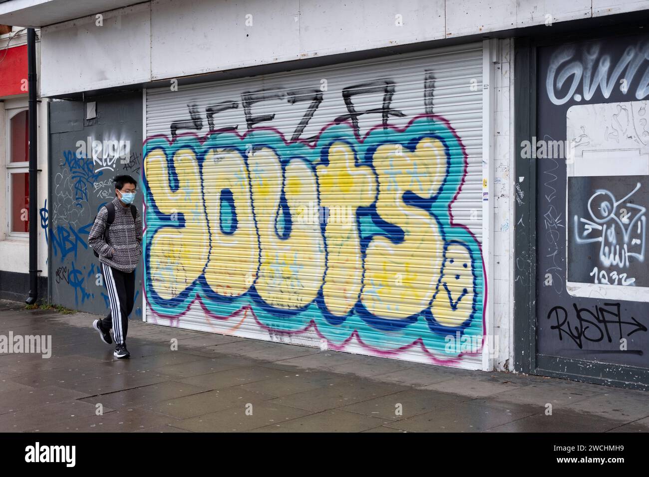 Closed down retail businesses with shutters down and graffiti spelling ...