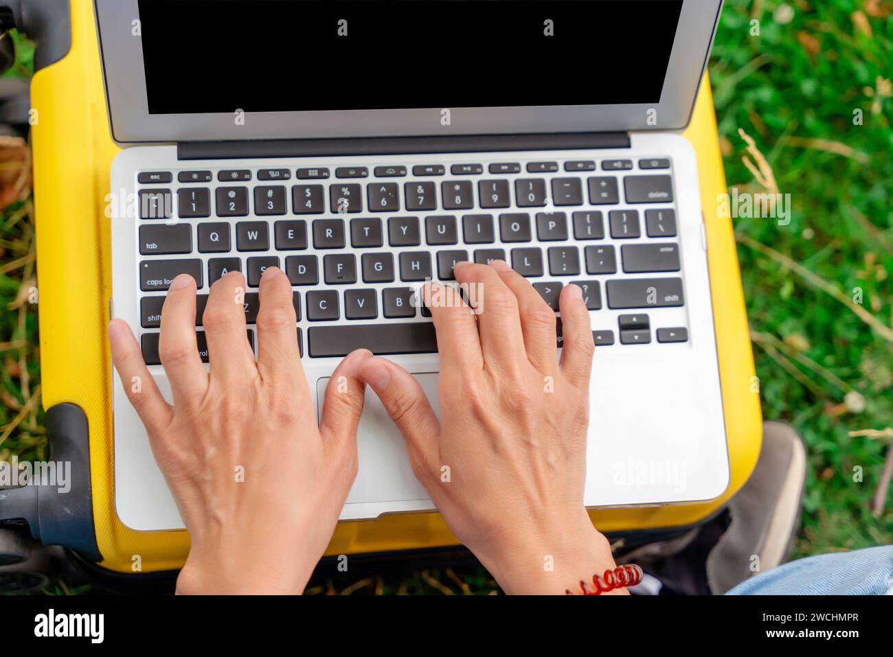 asian woman in blue jacket using laptop in public park using internet ...
