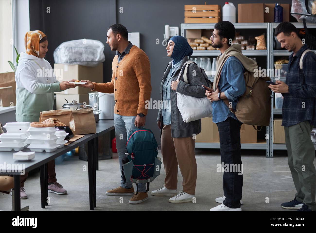 Full length side view of group of Middle Eastern people standing in ...