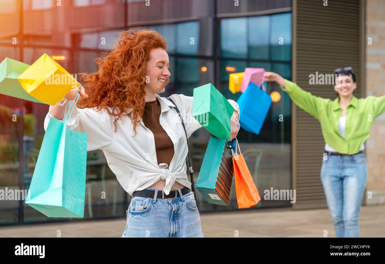 women with colorful bags having fun time with shopping in urban city ...
