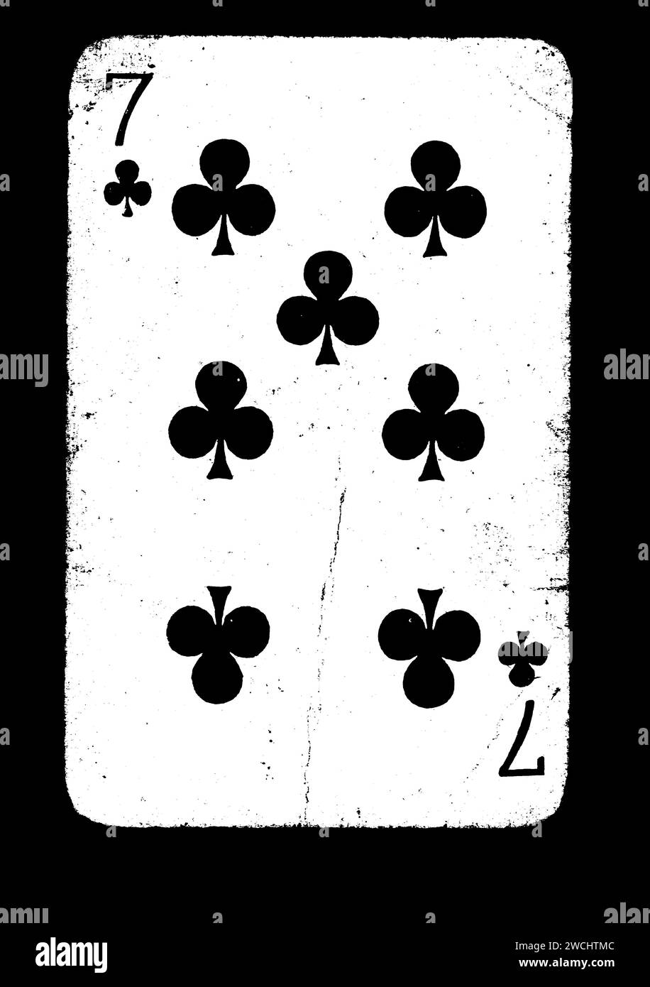 A vintage seven of clubs playing card isolated on a black background ...