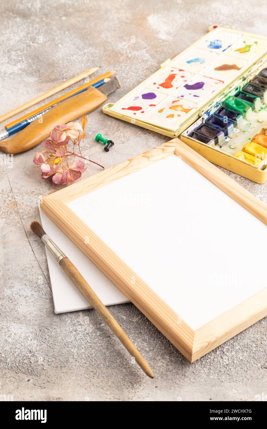 Drawing accessories set: brushes, pencils, watercolor, frame on brown ...