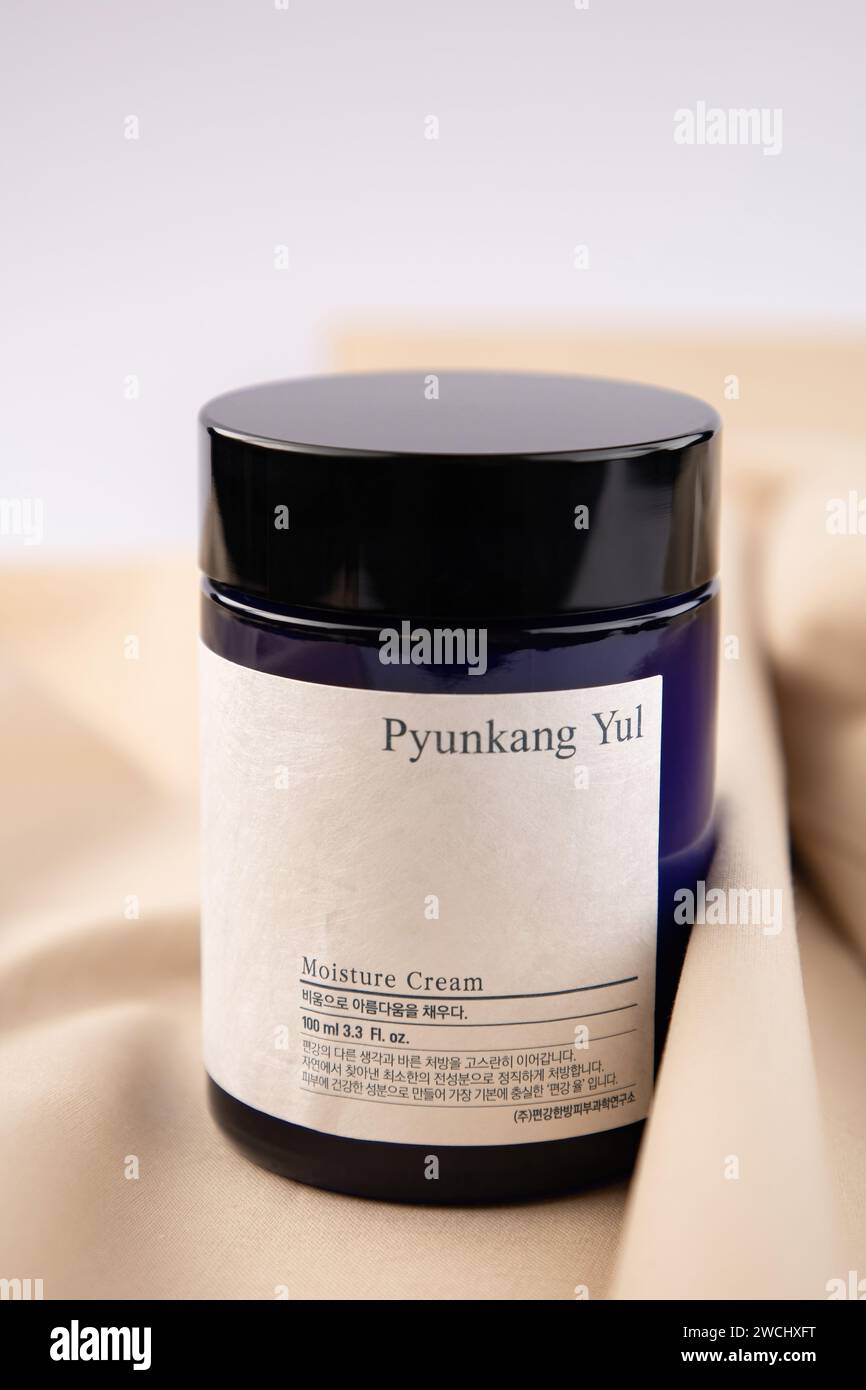 A glass bottle of Pyunkang Yul brand facial moisturizer stands on a ...