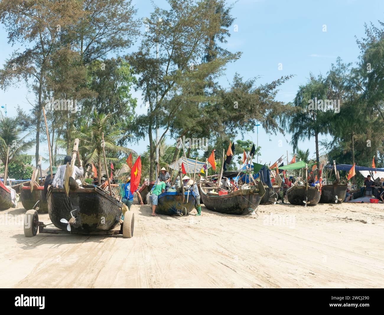 Fishermen at Sam Son Beach, Thanh Hoa, Vietnam with their boats at the ...