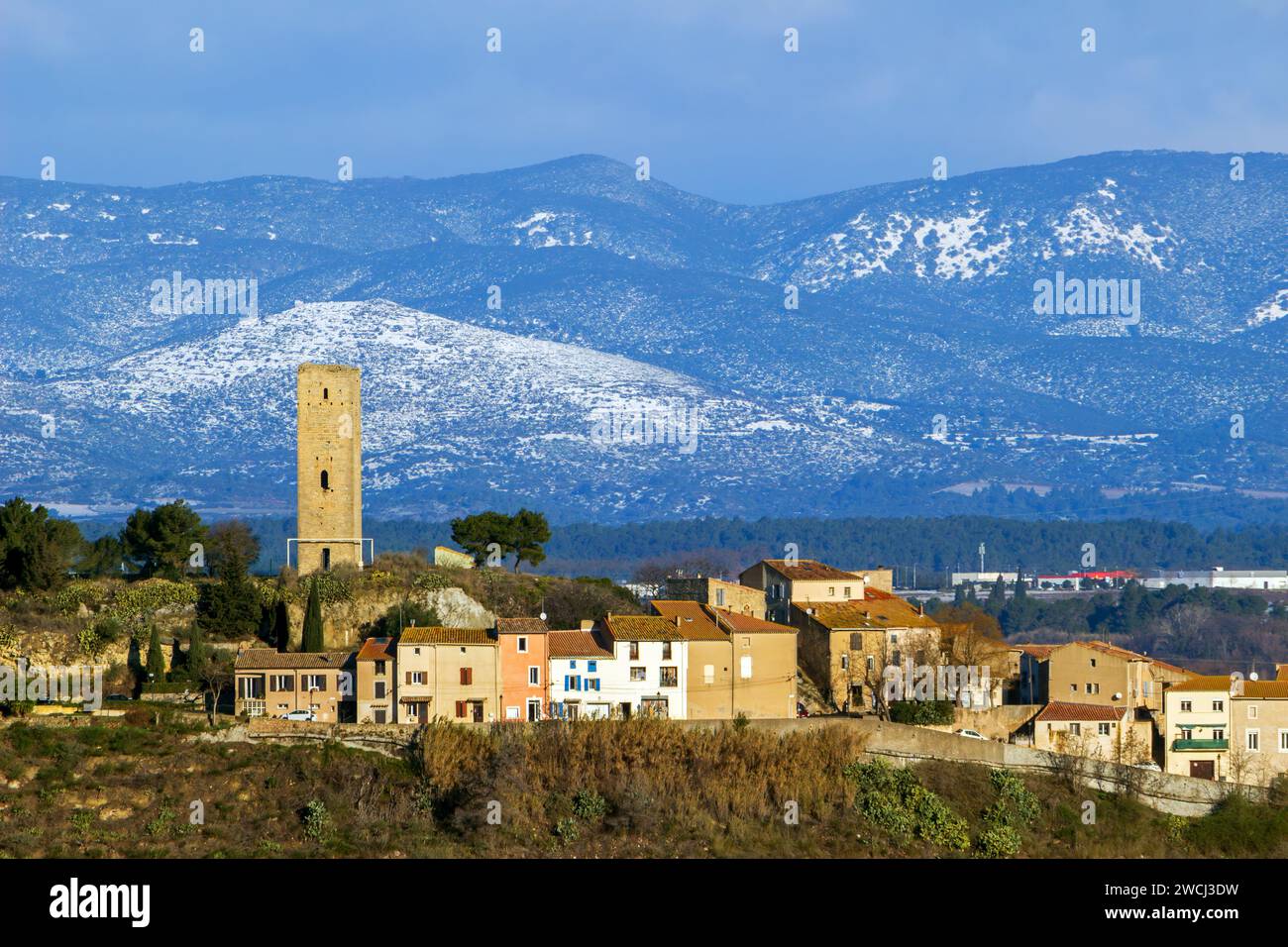 View of the village of Montady and the freshly snow-covered mountains ...