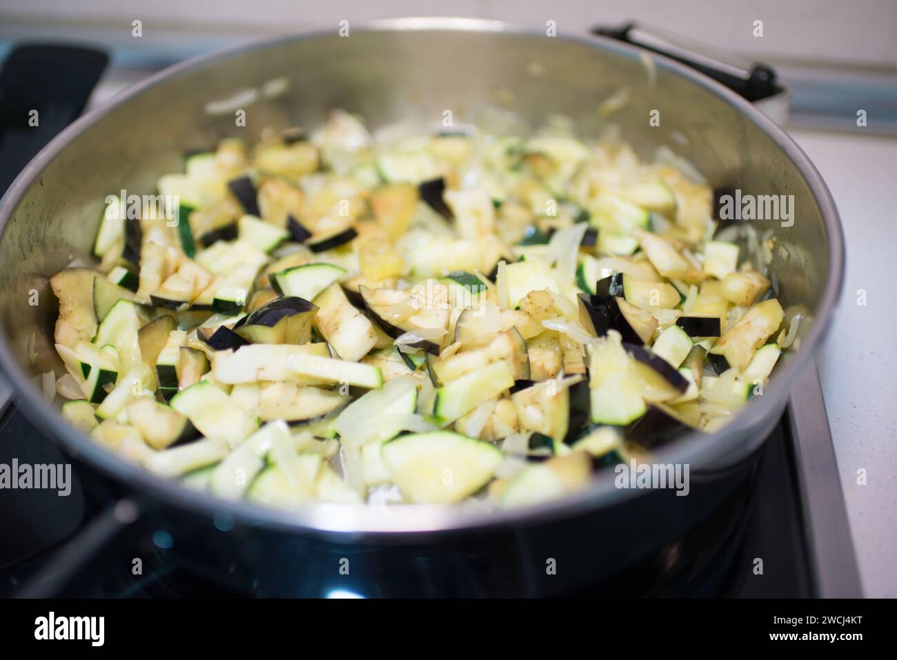 Cooking pan heating diced vegetables. Domestic kitchen Stock Photo - Alamy