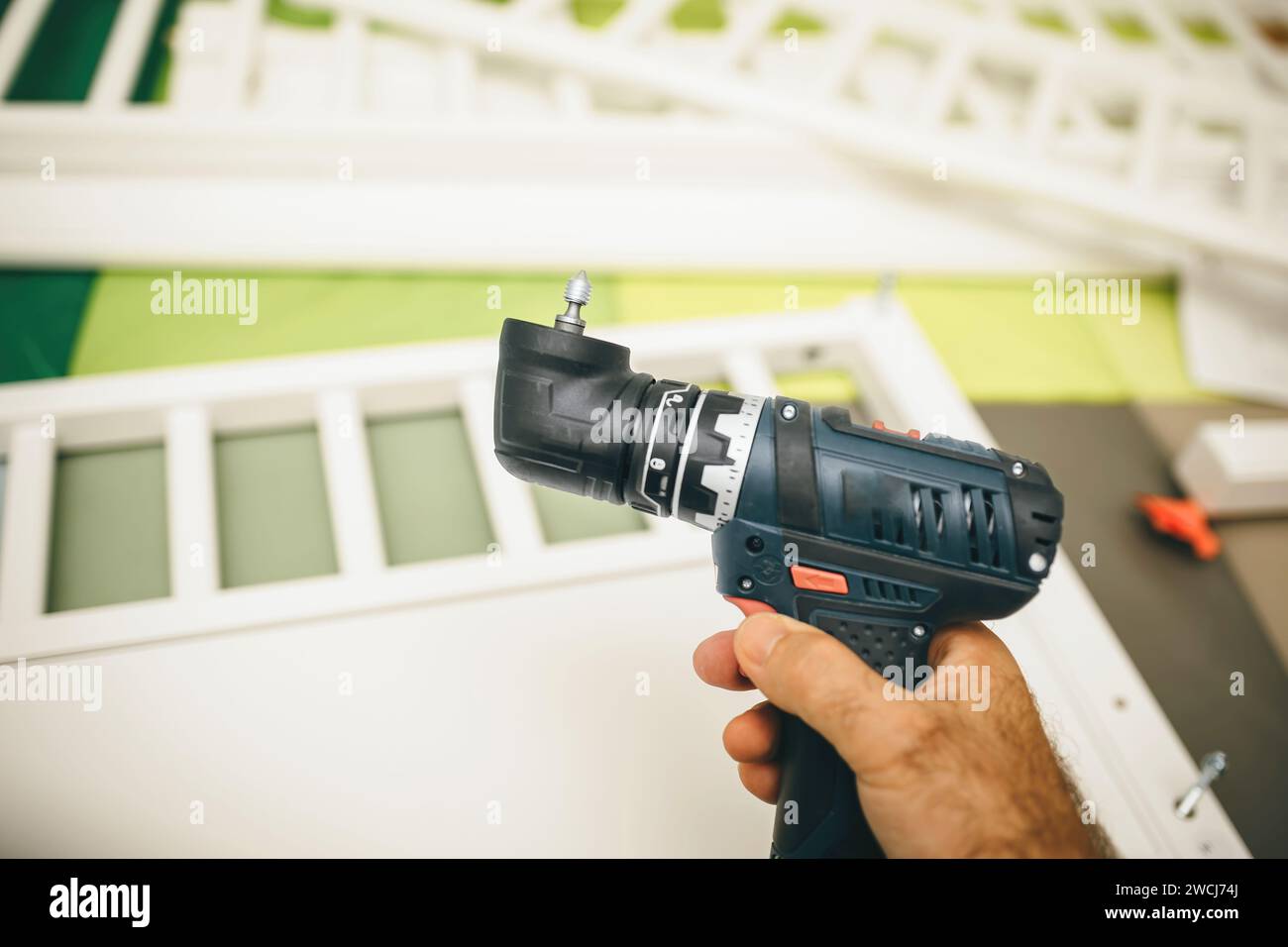 A persons hand firmly grips a cordless electric drill with a bit ...