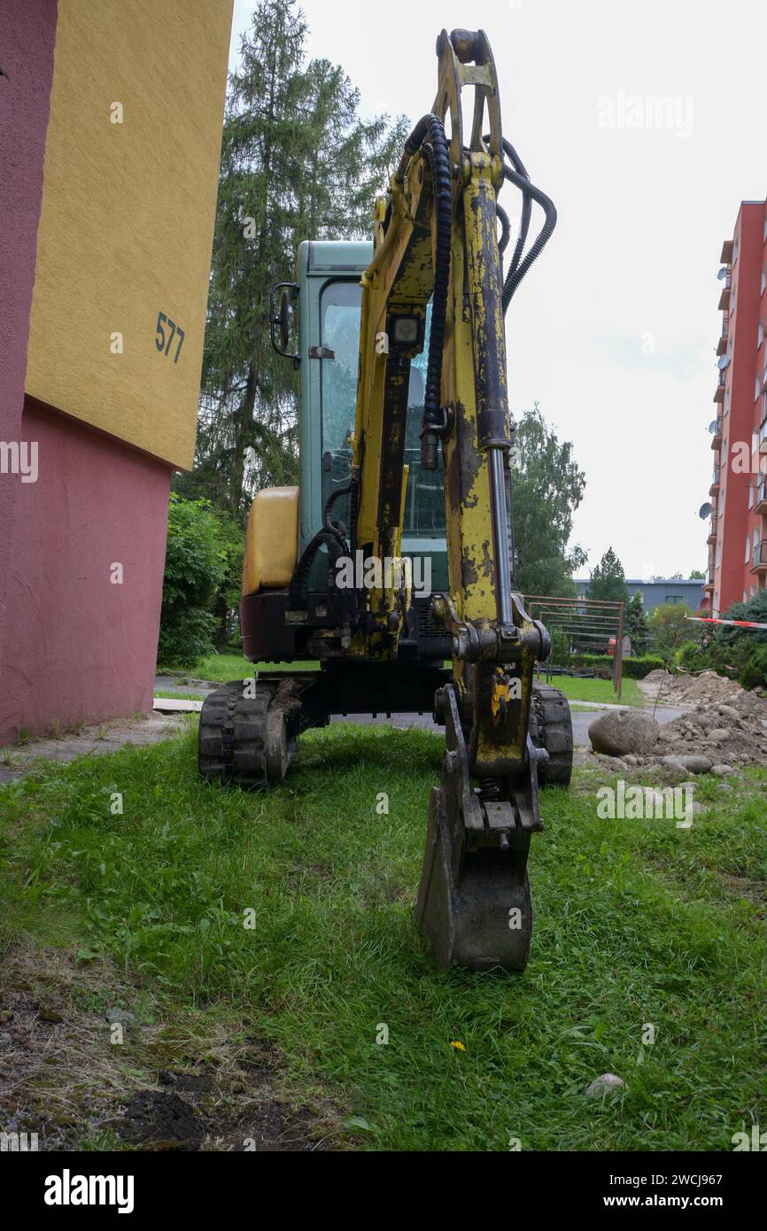 Mini excavator digging pits for optical cable Stock Photo - Alamy
