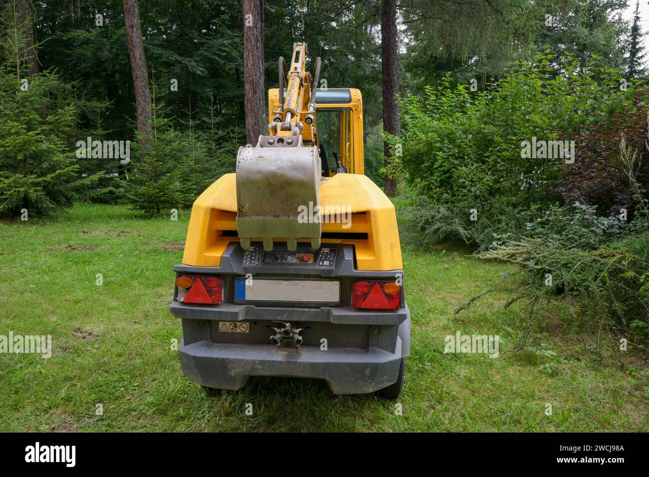 Mini excavator digging pits for optical cable Stock Photo - Alamy