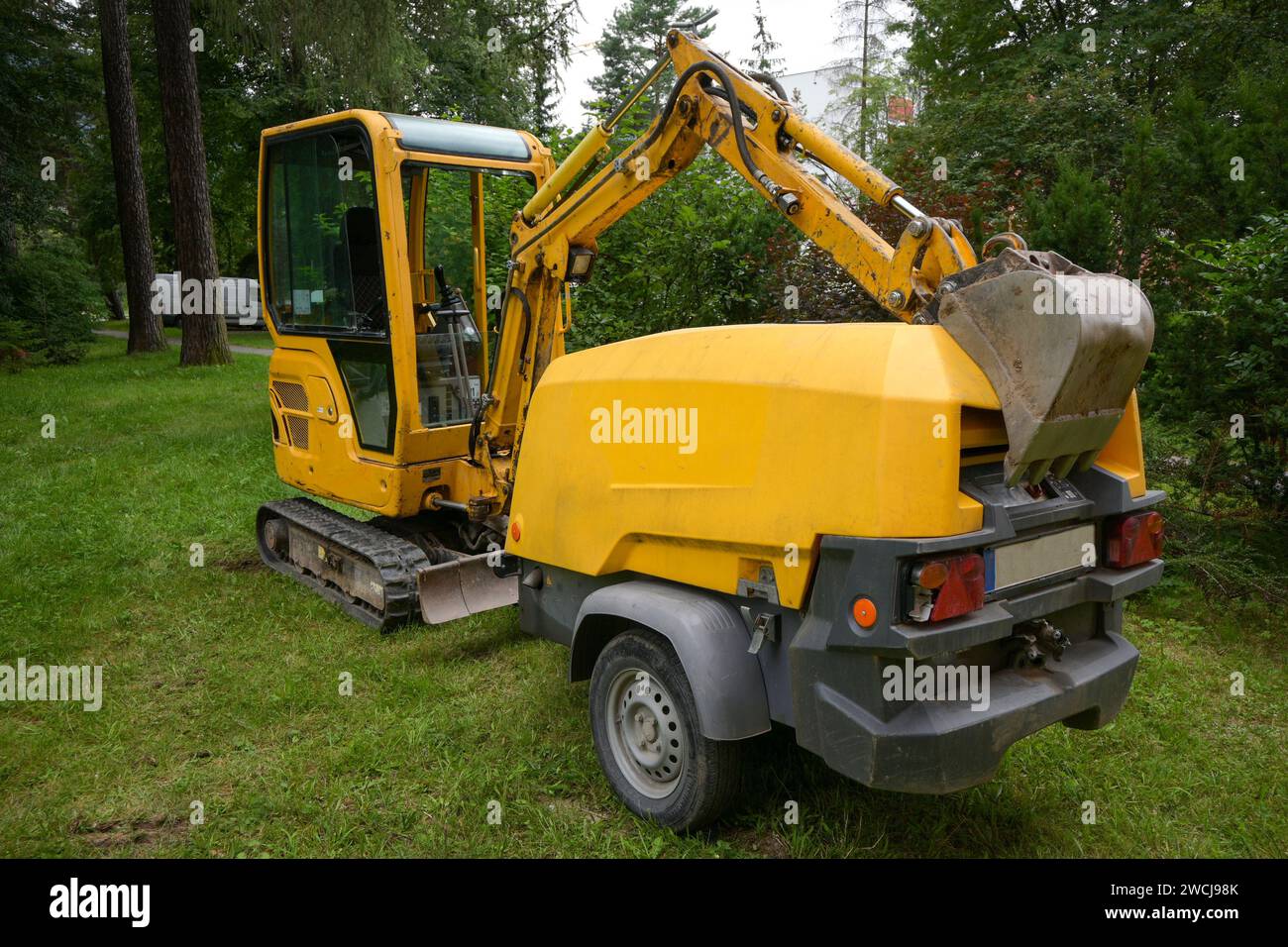 Mini excavator digging pits for optical cable Stock Photo - Alamy