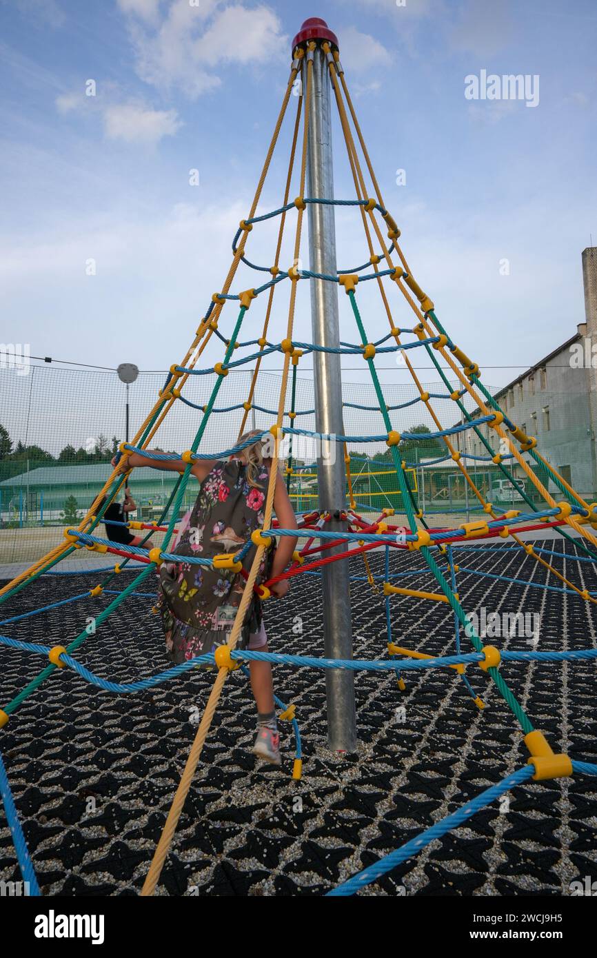 A girl playing on the playground on a spider web Stock Photo - Alamy