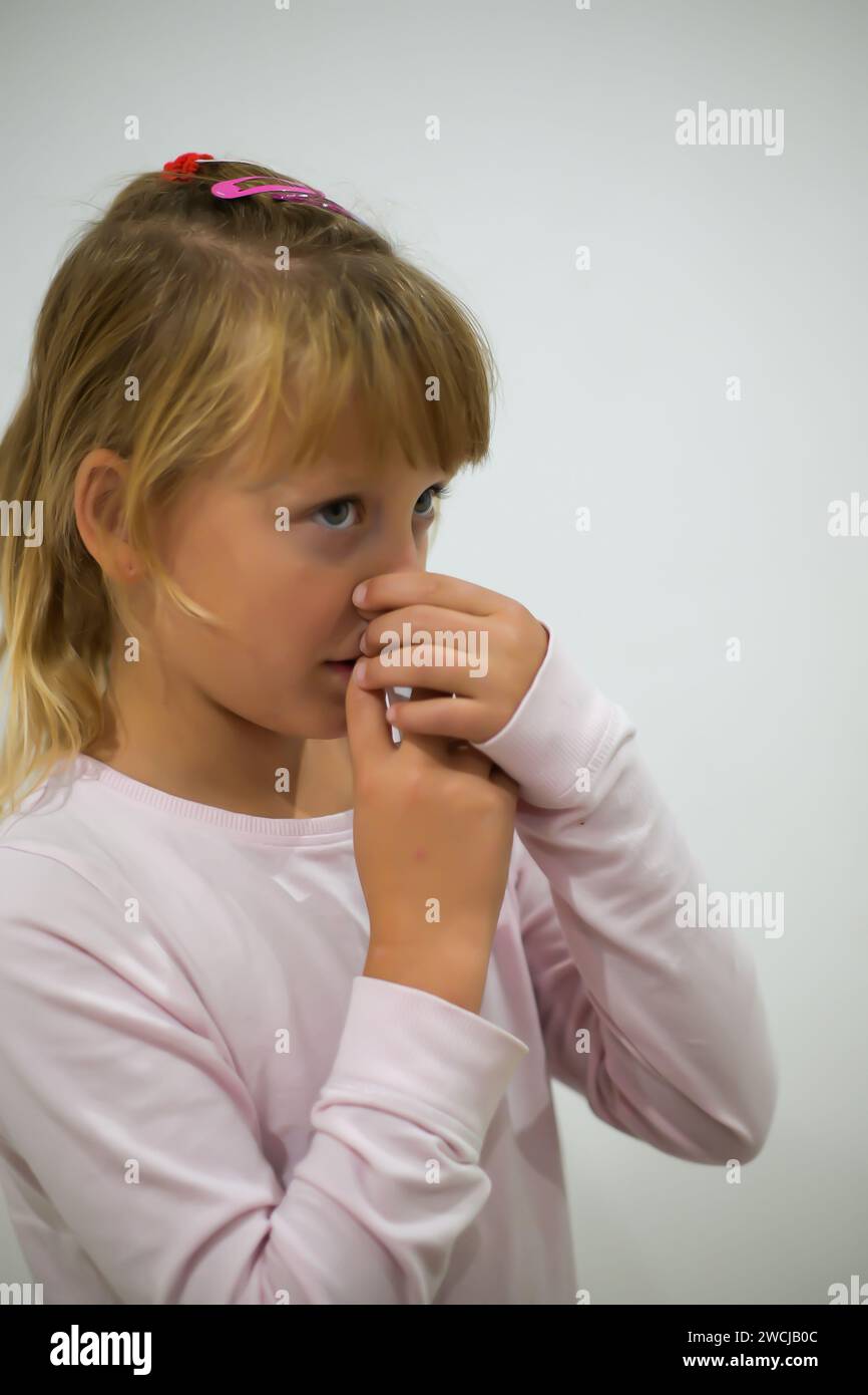 little embittered girl in pajamas sprays her nose with anti-pneumonia ...