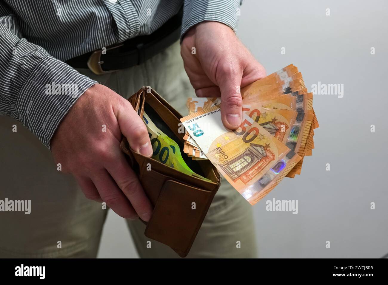 a guy pulls money out of his wallet and counts it, financial crisis ...