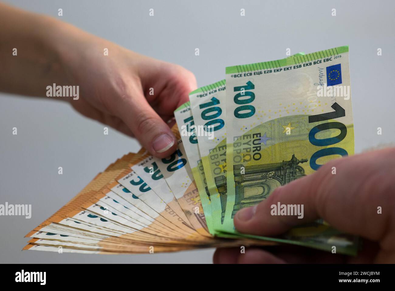 a man hands a woman money arranged in the shape of a fan, 50 euro ...