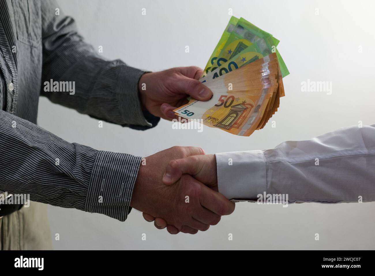 Hand shake with currency hi-res stock photography and images - Alamy