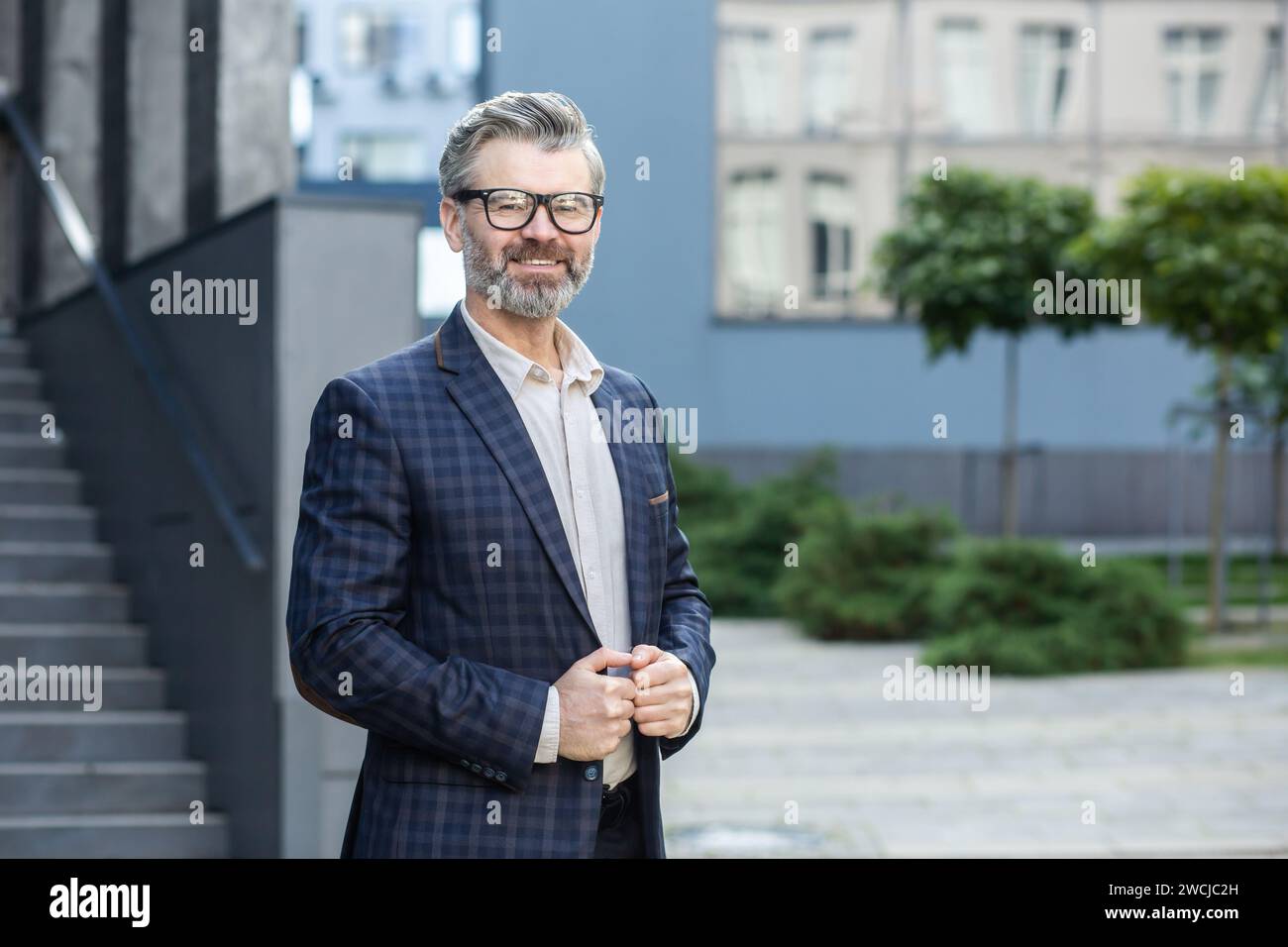 Mature male executive looking content outdoors. He portrays success and ...