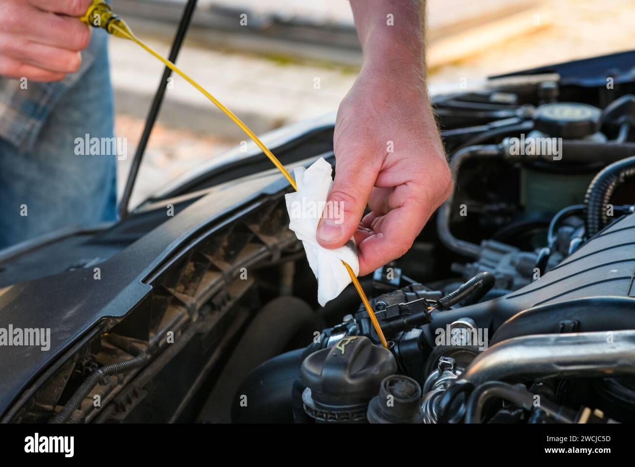 the mechanic checks the oil level in the car, close-up view and on a ...