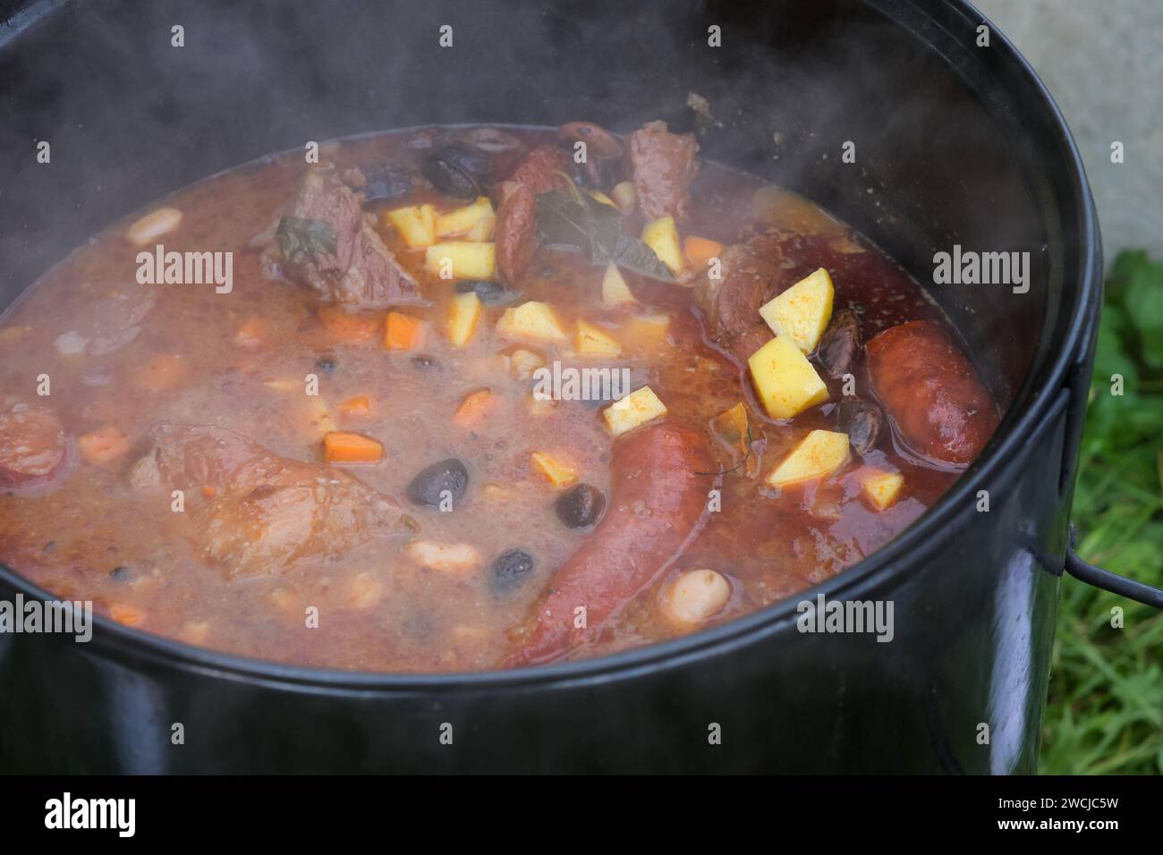 bean goulash cooked over an open fire in a large cauldron in the open ...