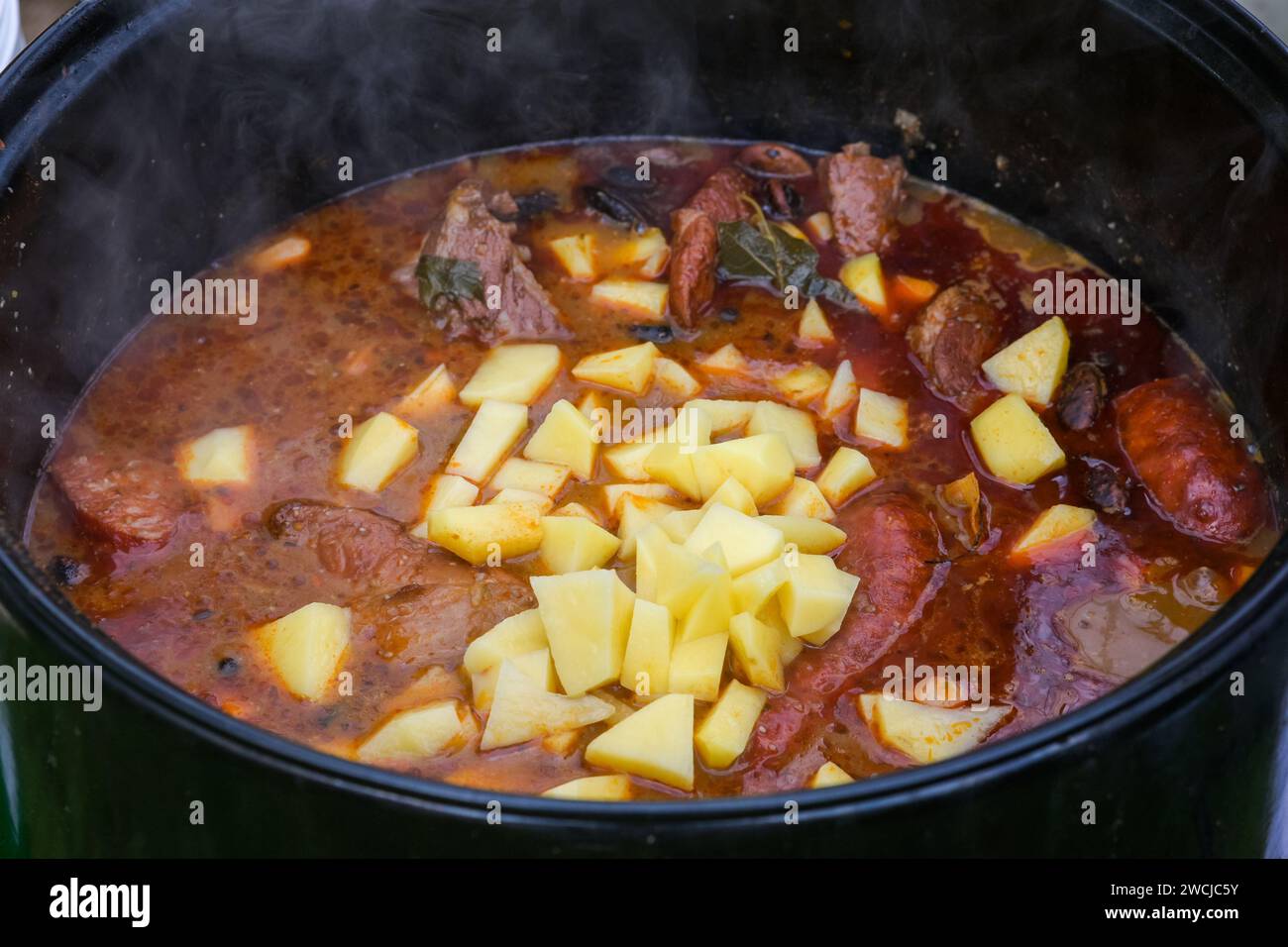bean goulash cooked over an open fire in a large cauldron in the open ...