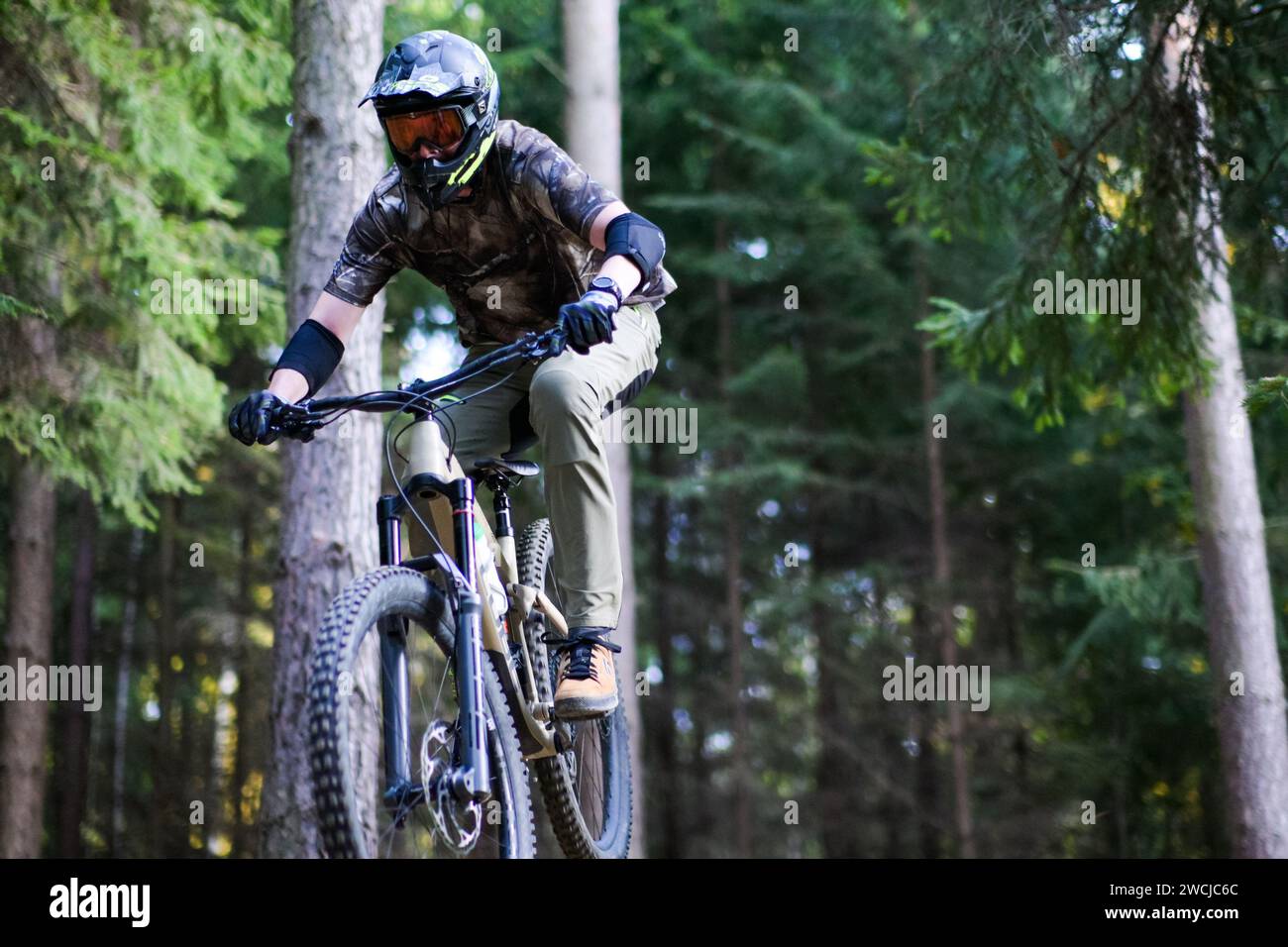 Professional athlete high jump on a mountain bike in the forest, close ...