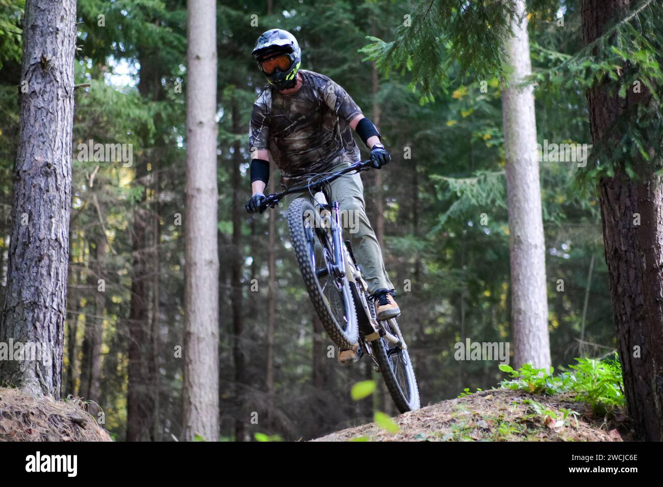 Professional athlete high jump on a mountain bike in the forest, close ...