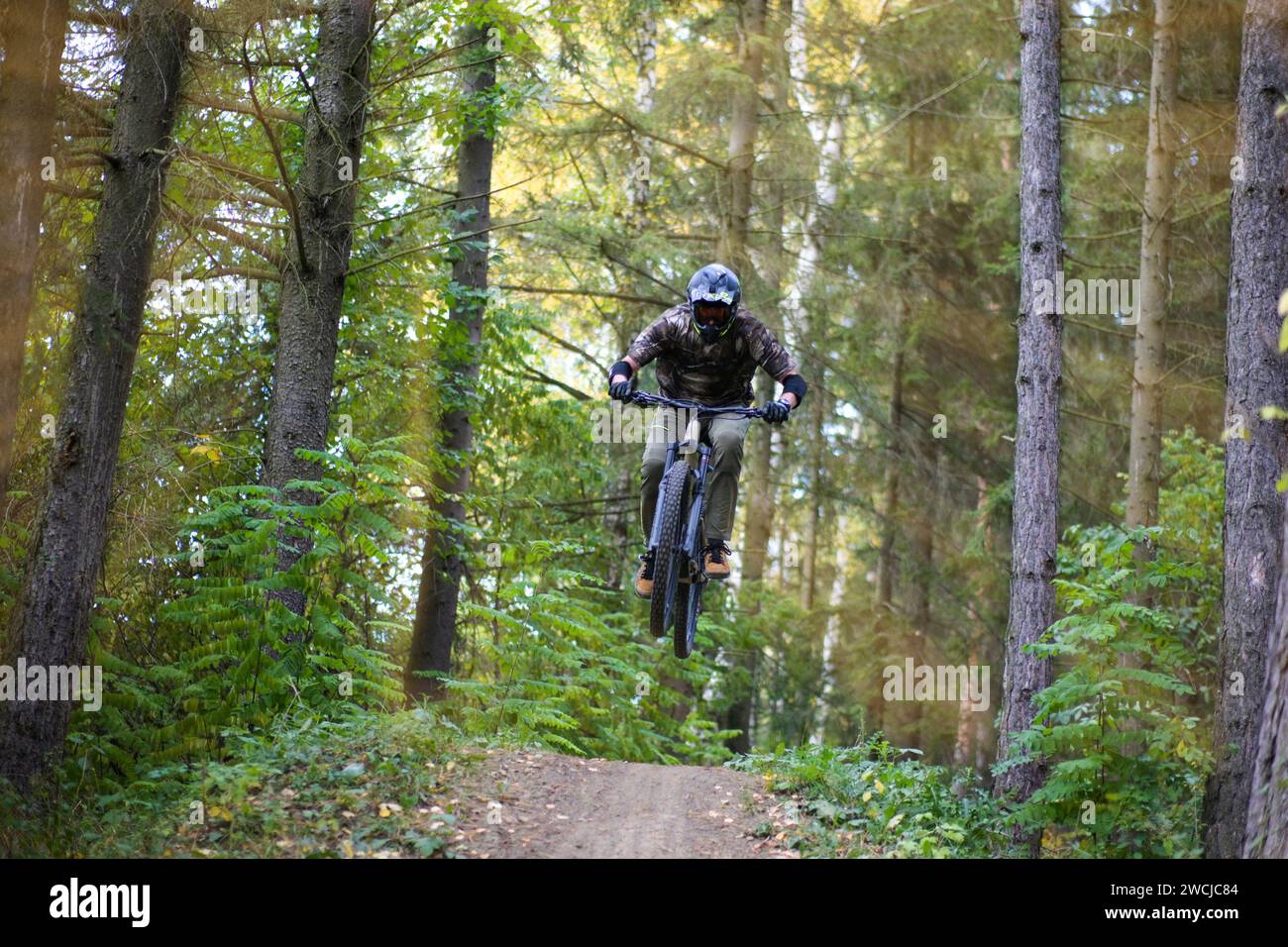 Professional athlete high jump on a mountain bike in the forest, close ...