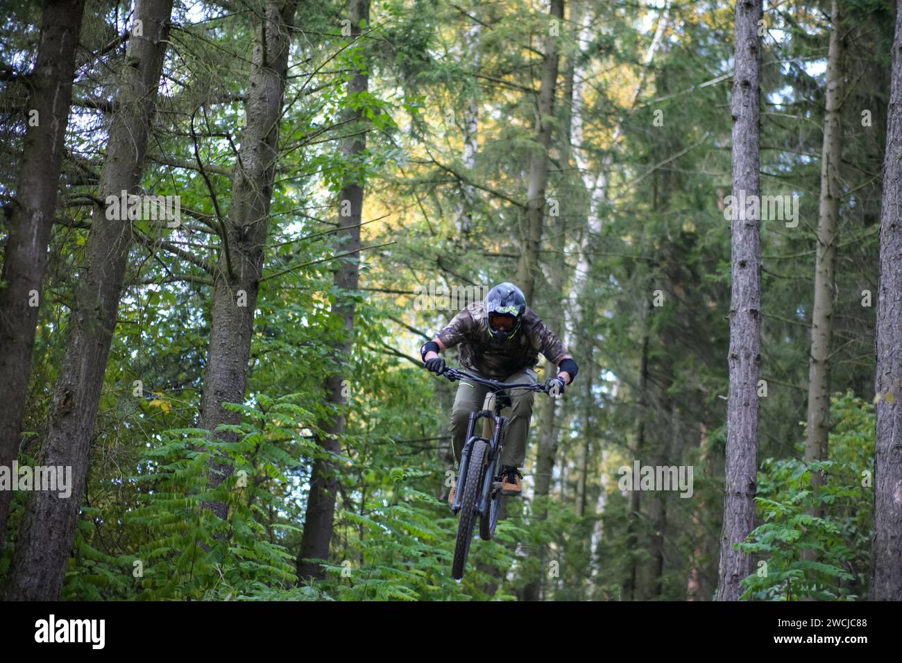 Professional athlete high jump on a mountain bike in the forest, close ...