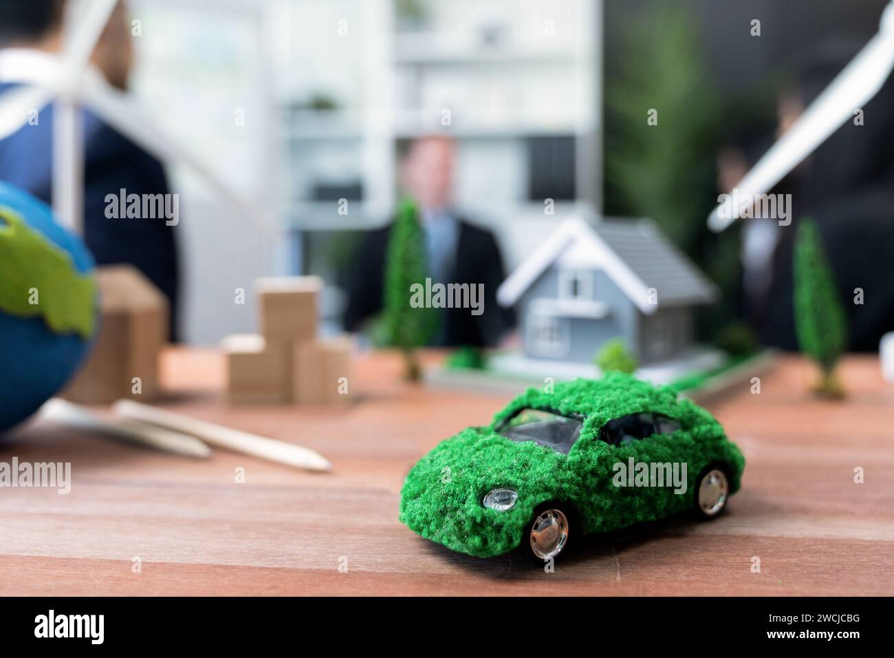 EV car model on table with blurred business people planning business ...