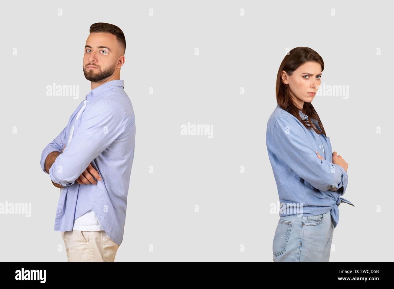 Upset couple standing back-to-back with crossed arms, disagreement ...