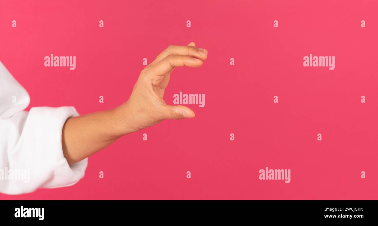 Female hand holding invisible object over pink background Stock Photo ...