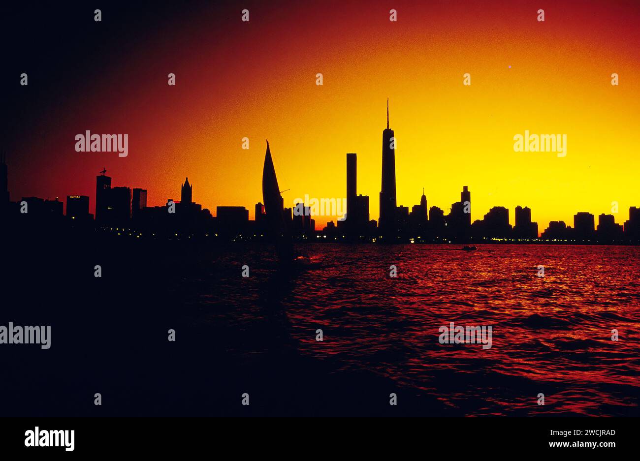 Vibrant Sunset Silhouetting City Skyline over Water Stock Photo - Alamy