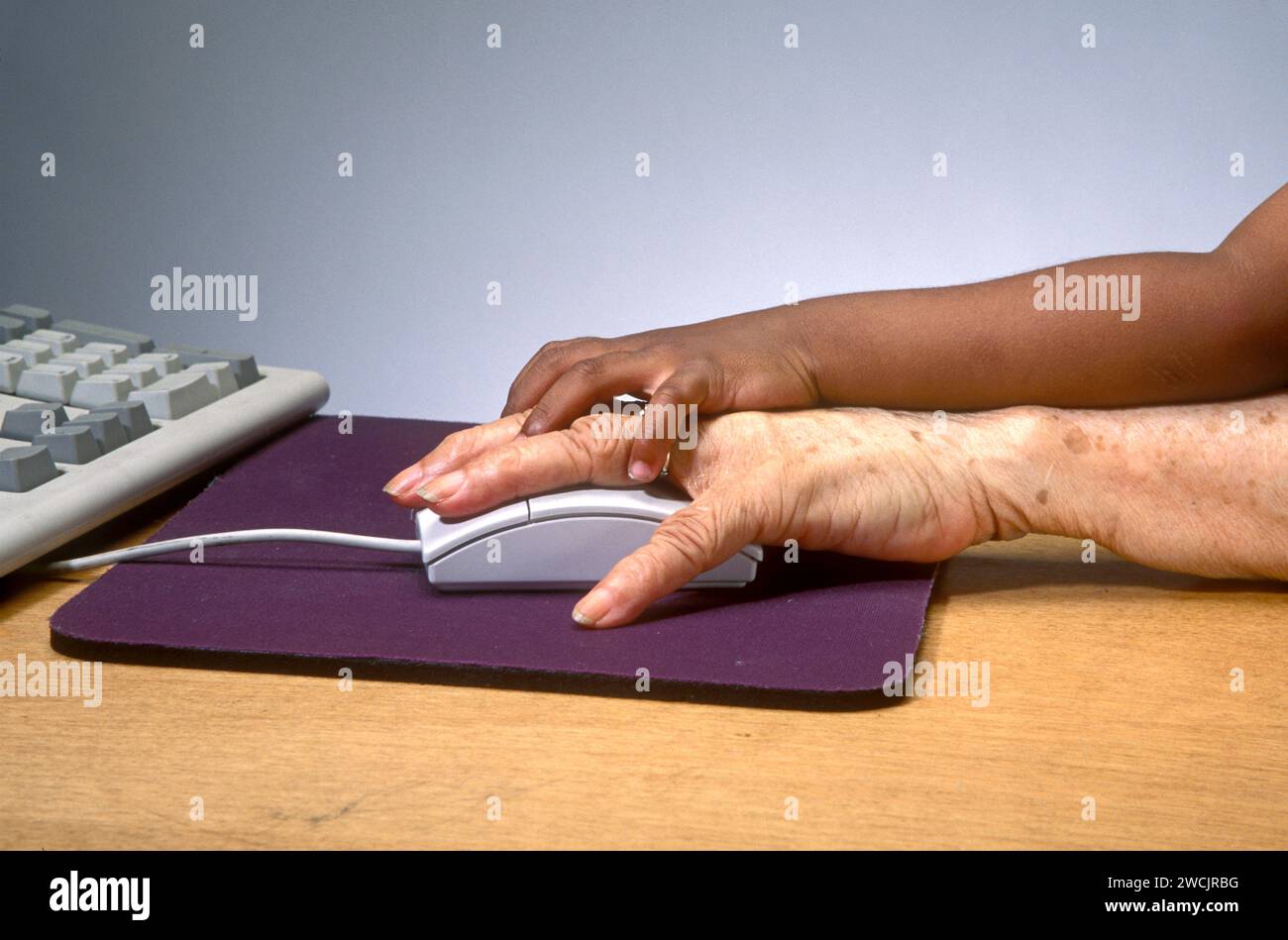 Close-up of Child Hand helping Senior Using Computer Mouse and Keyboard Stock Photo - Alamy