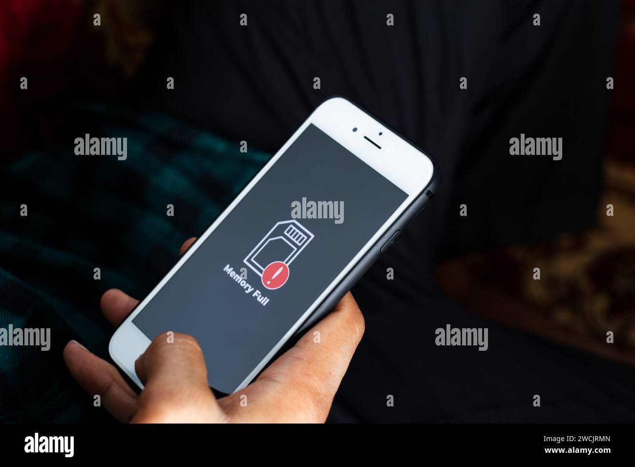 Close up of male hand holding a smart phone with sign full storage icon ...