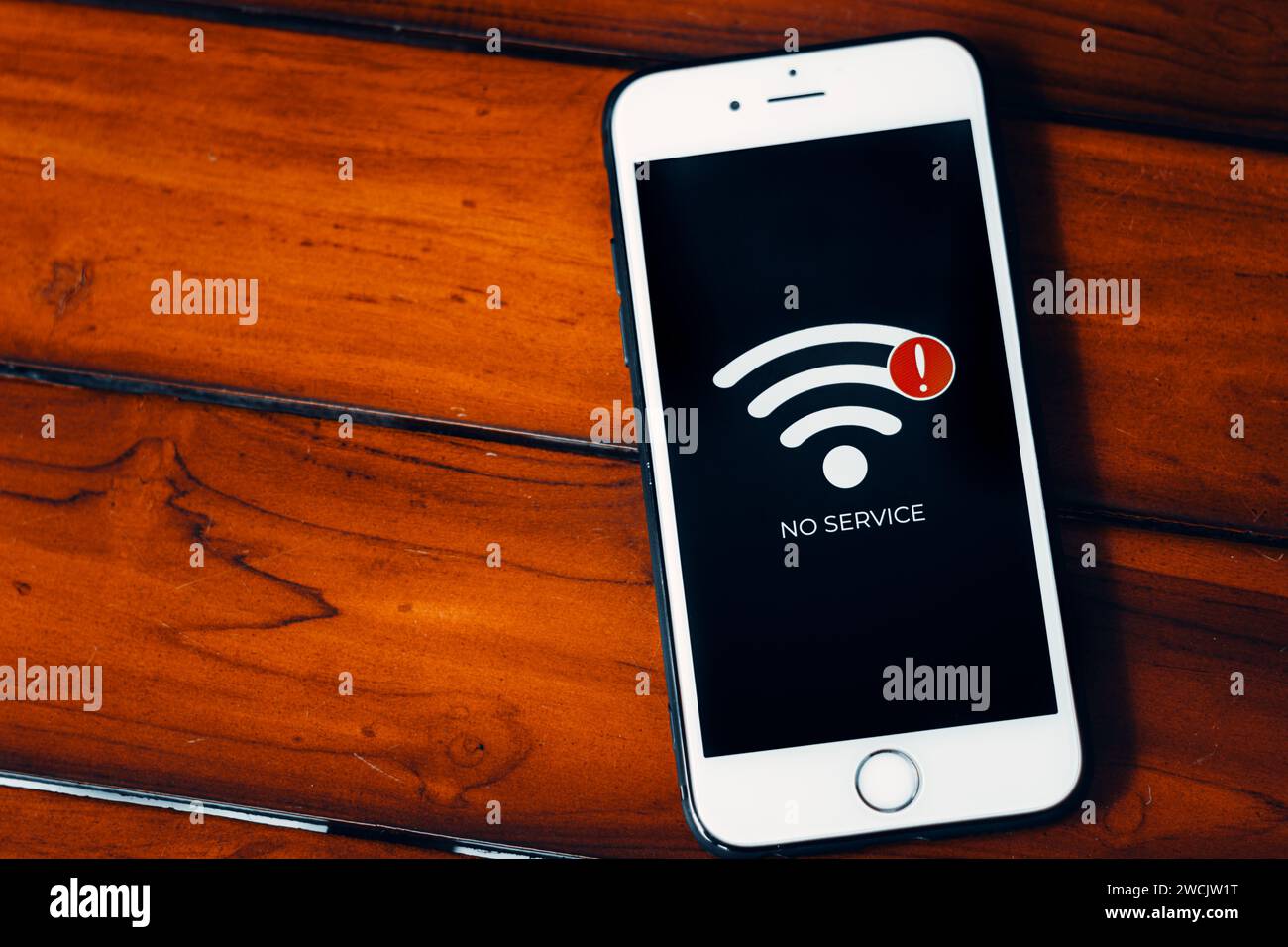 Smart phone with sign no service on screen on wooden background ...