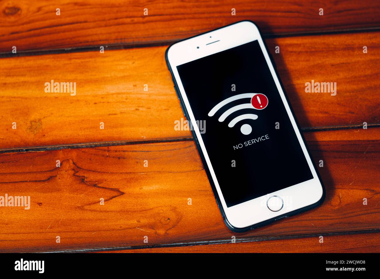 Smart phone with sign no service on screen on wooden background ...