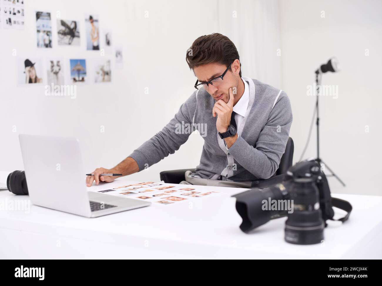 Photographer, editing and thinking with computer in office with media ...