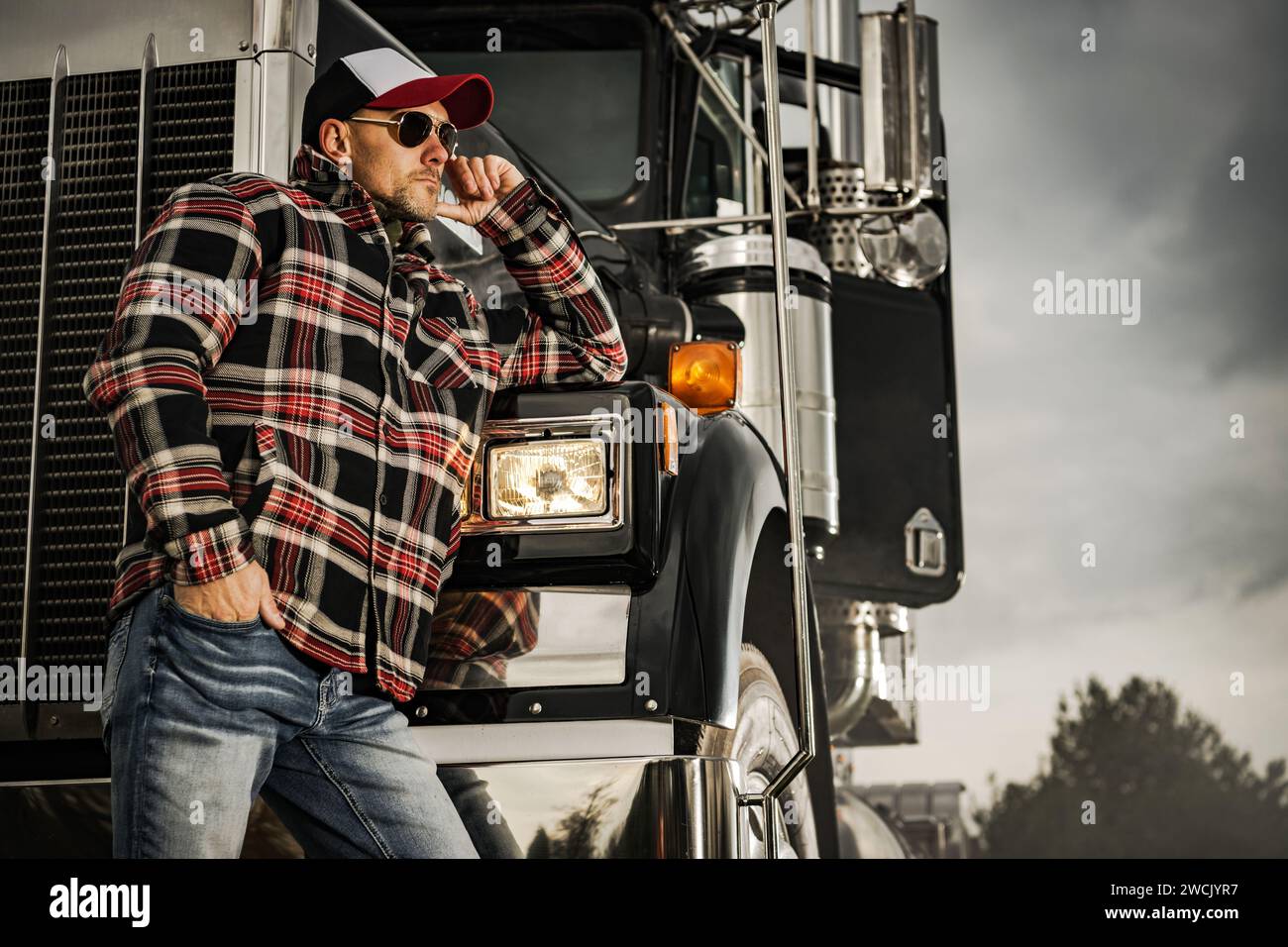 Caucasian Semi Truck Driver in His 40s Relaxing Next to His Truck ...