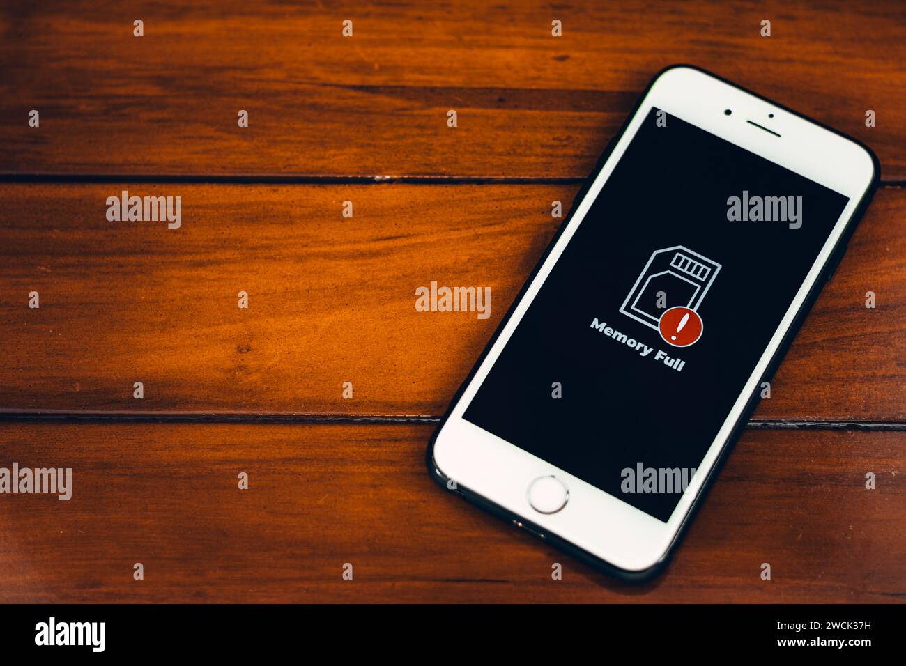 Smartphone with full storage icon on screen on wooden background ...