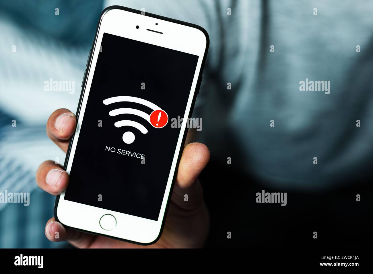 Close up of male hand holding a smart phone with sign no service on ...