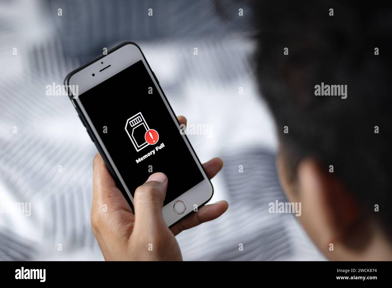male hand holding a smart phone with sign full storage icon on screen ...