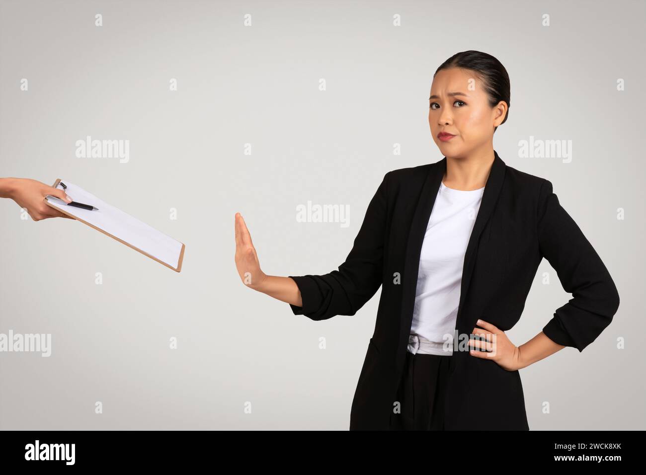 Determined Asian businesswoman in a black suit making a rejecting ...