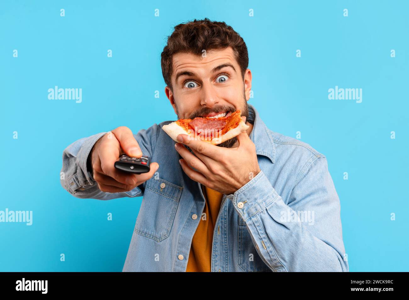 Funny Hungry Millennial Man Eating Pizza And Watching TV, Studio Stock ...