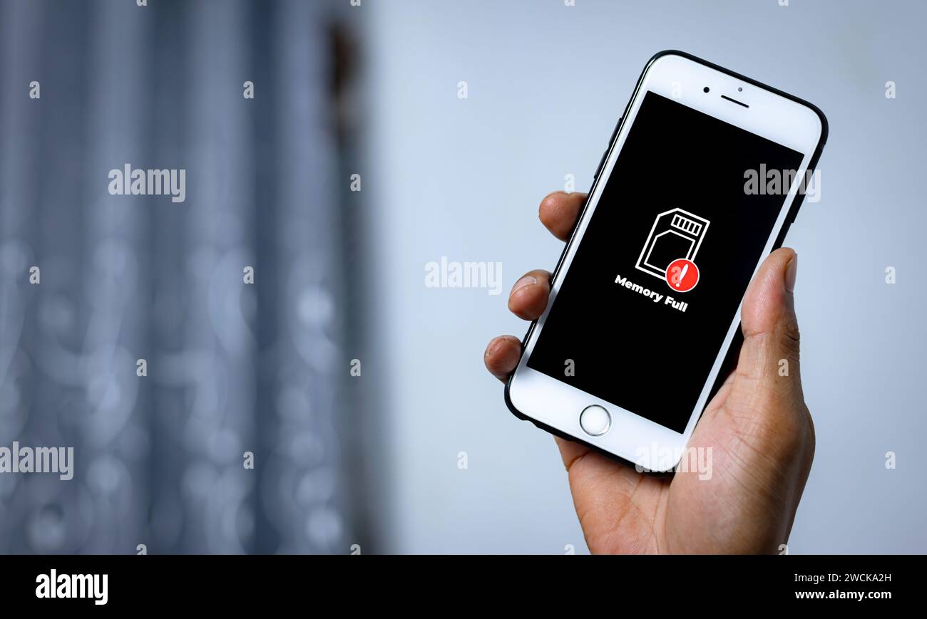 male hand holding a smart phone with sign full storage icon on screen ...
