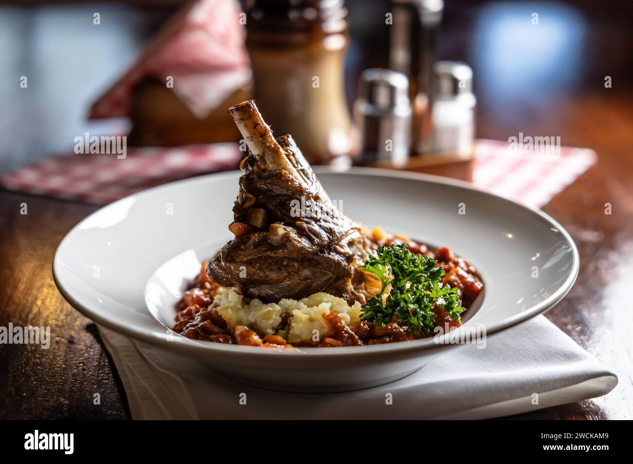 Confit lamb calf on mashed potatoes and baking sauce. Roasted leg of ...